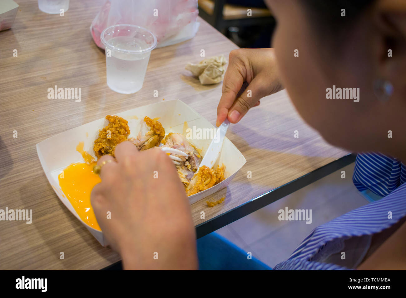 Asian women eating fried chicken, focus woman hand hold fried chicken ...