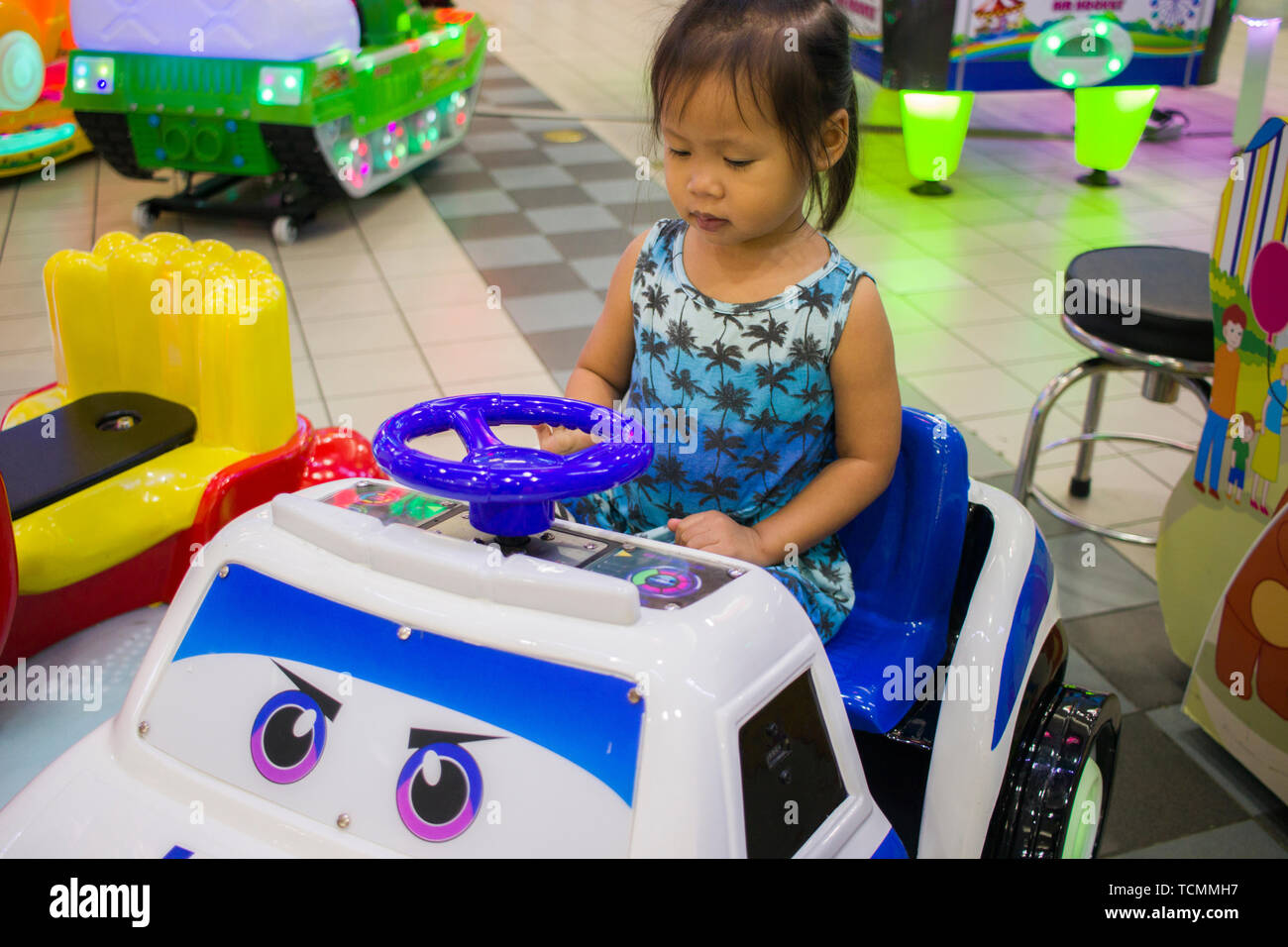 Little child drives children toy car in amusement park summer day High ...