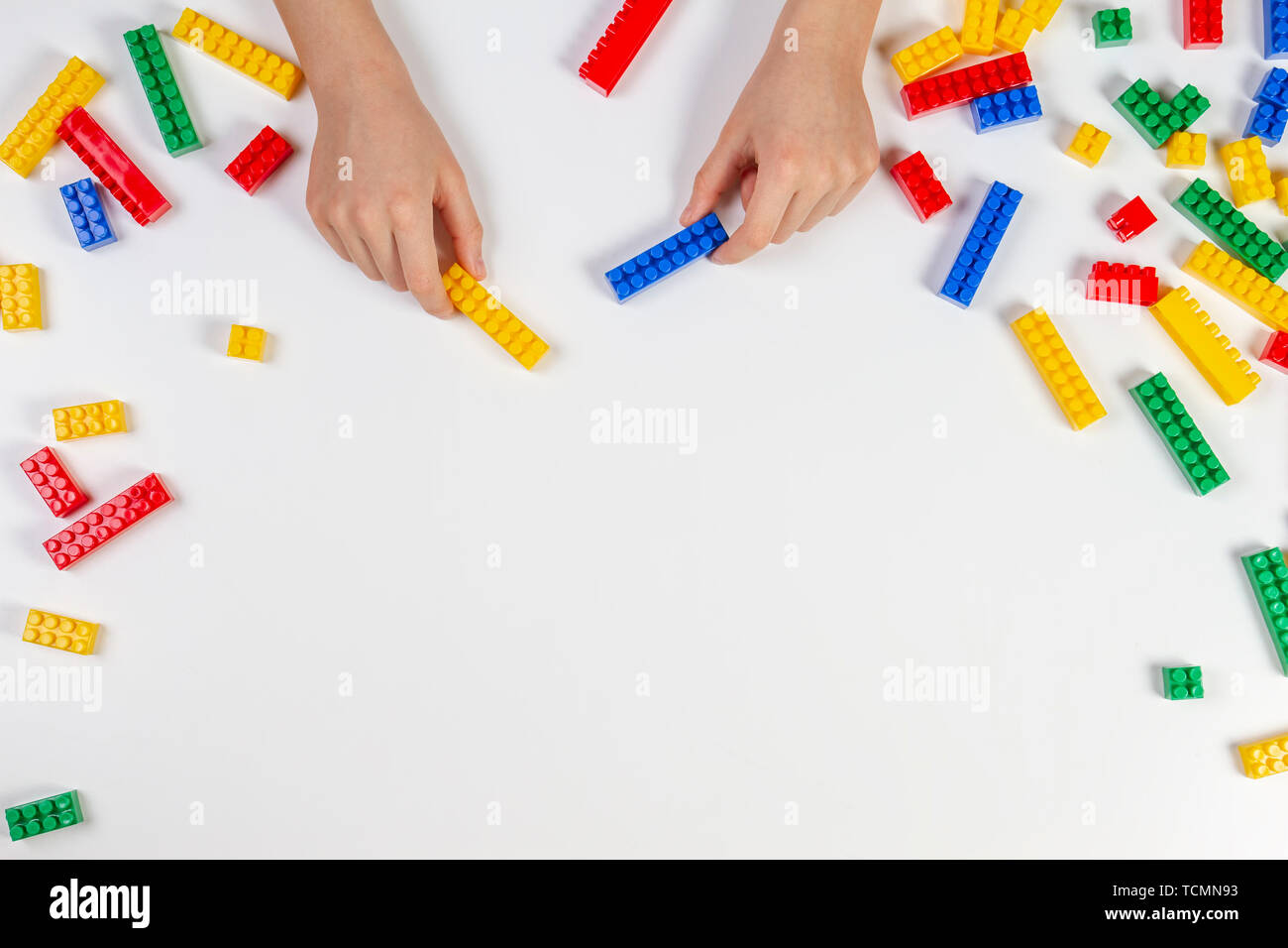 Kid hands playing with colorful building plastic bricks on white ...