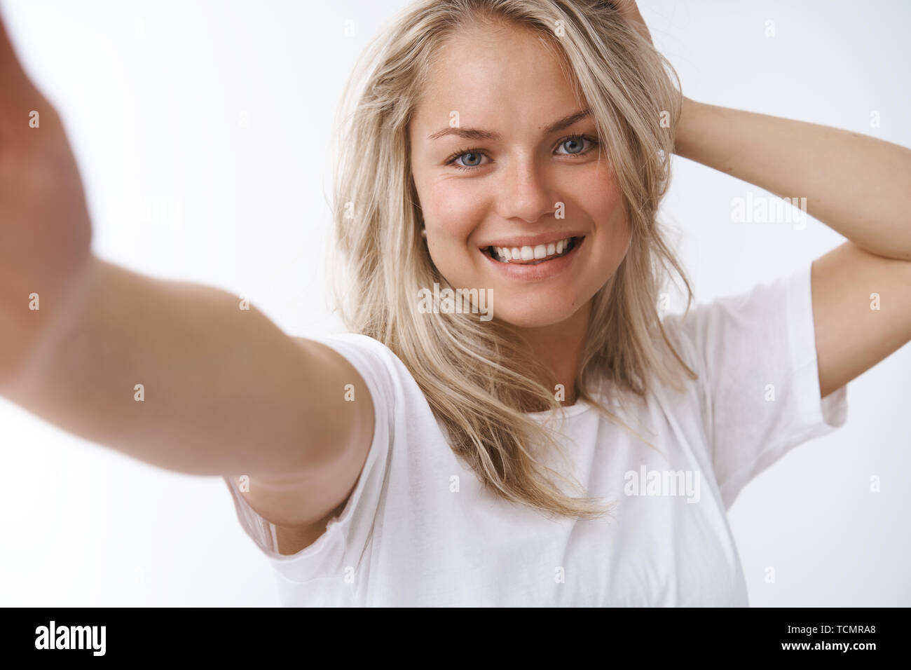 Woman taking selfie in morning on smartphone extending arm forward as ...