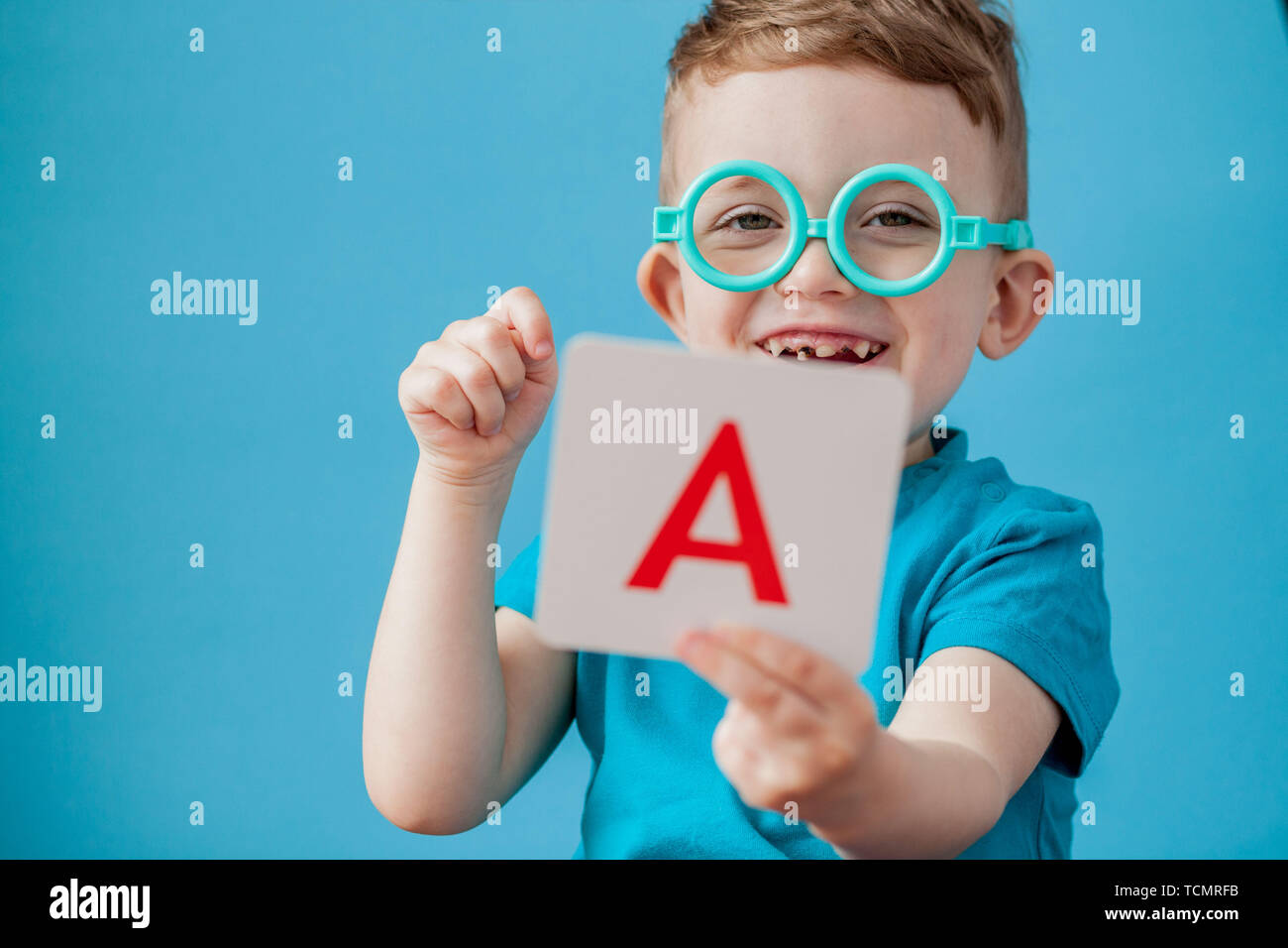 Cute little boy with letter on background. Child learn letters ...