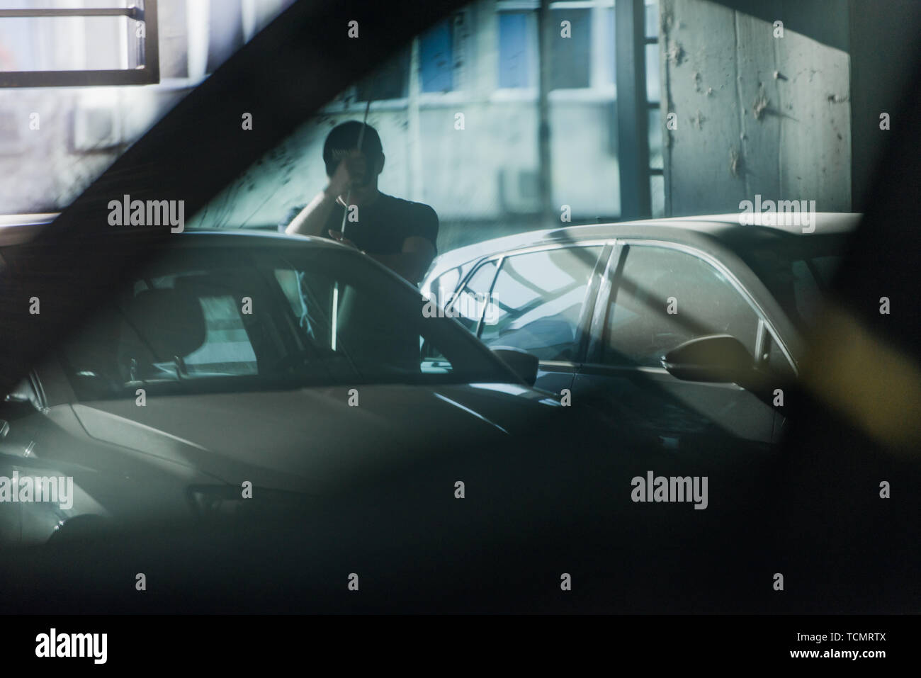 Masked man is stealing a car on the parking with wrecking bar Stock ...