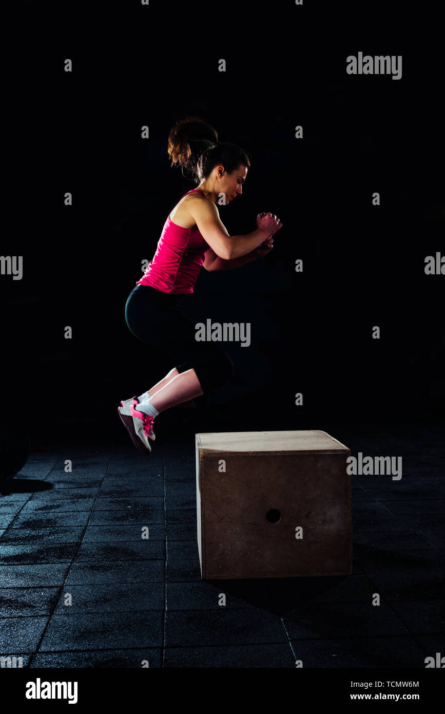 Young female athlete box jumping at a crossfit gym Stock Photo - Alamy