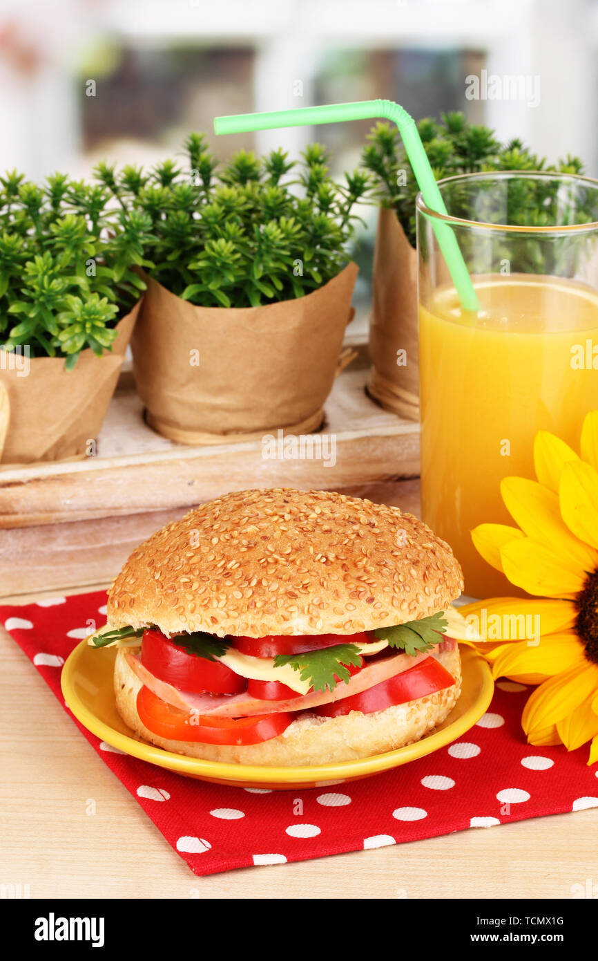 Appetizing sandwich on color plate on wooden table on window background ...