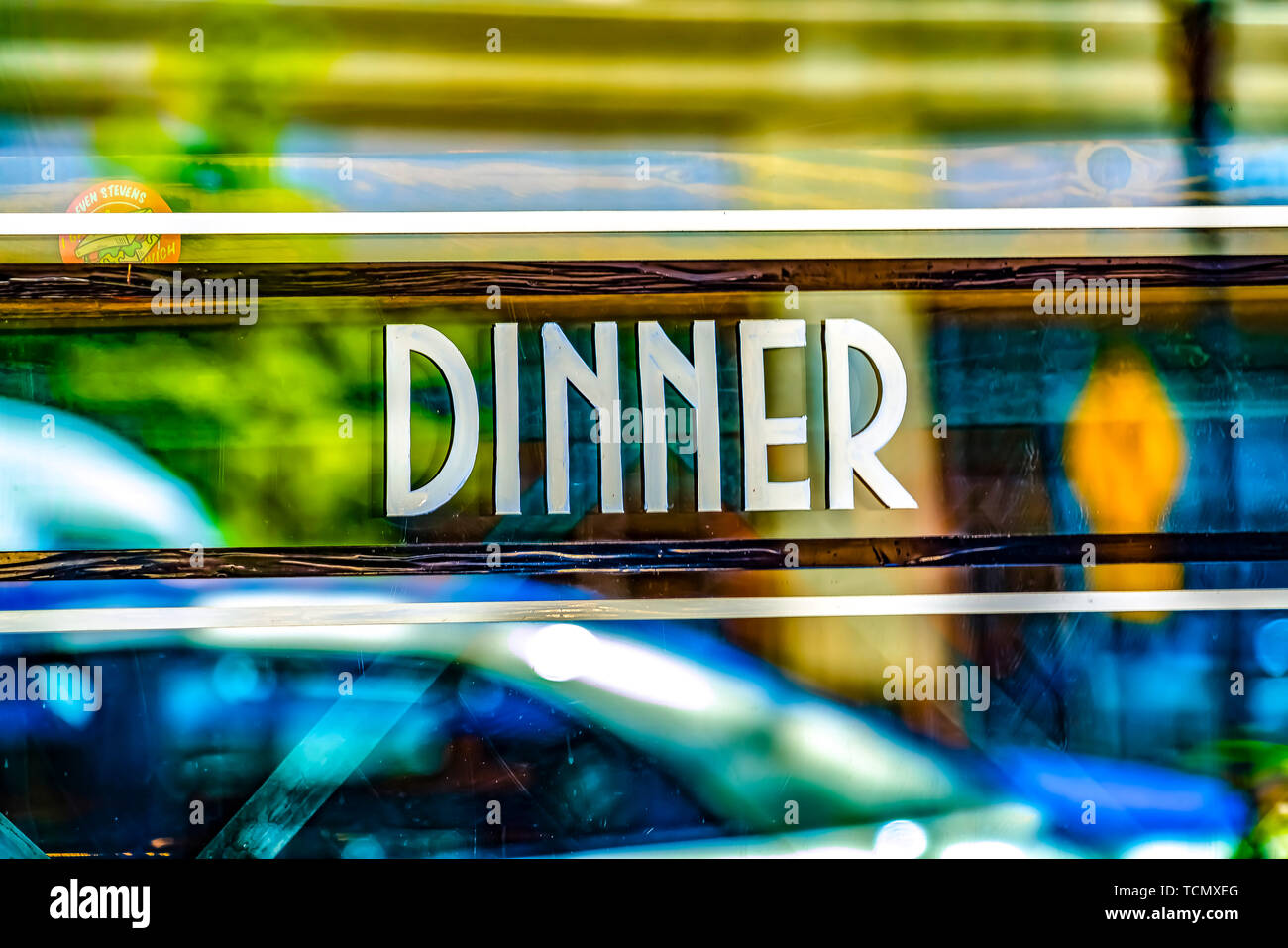 Close up view of the glass wall of a restaurant with a Dinner sign ...