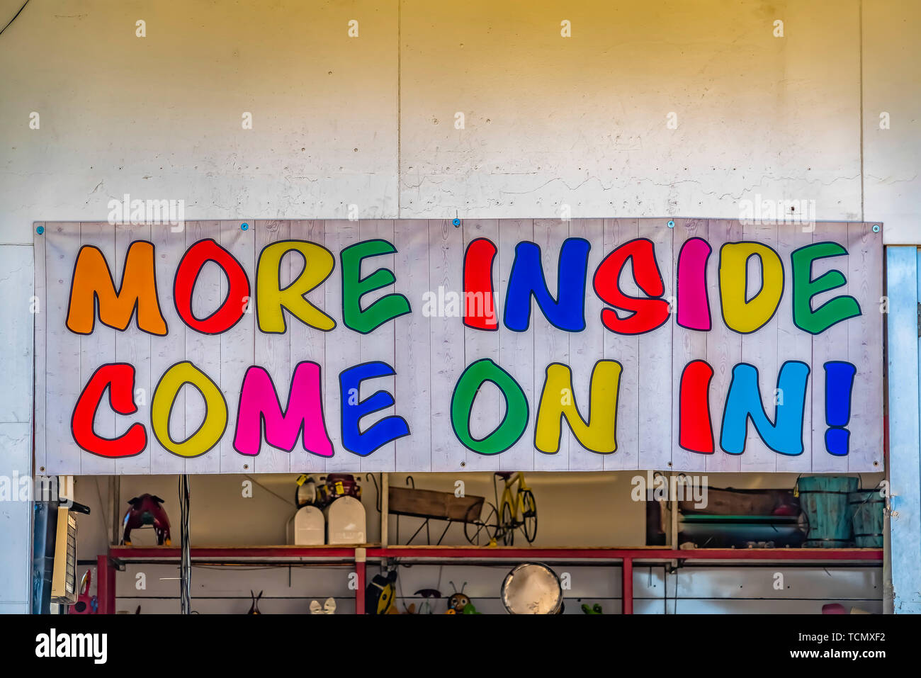 Sign at the entrance of a building that reads More Inside Come On In ...