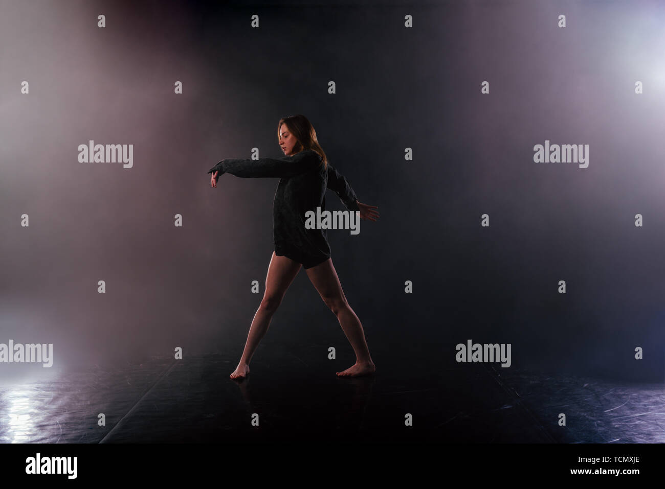 Shoeless female dance shows off her modern art dance moves while ...