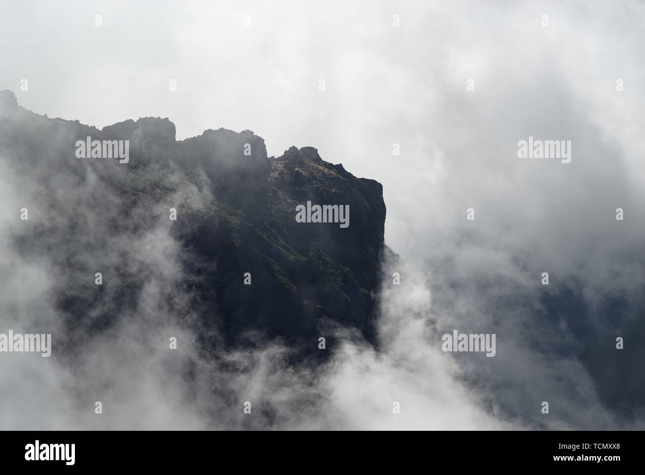 Dark rock formation inside of raised clouds. View from Pico do Arieiro ...