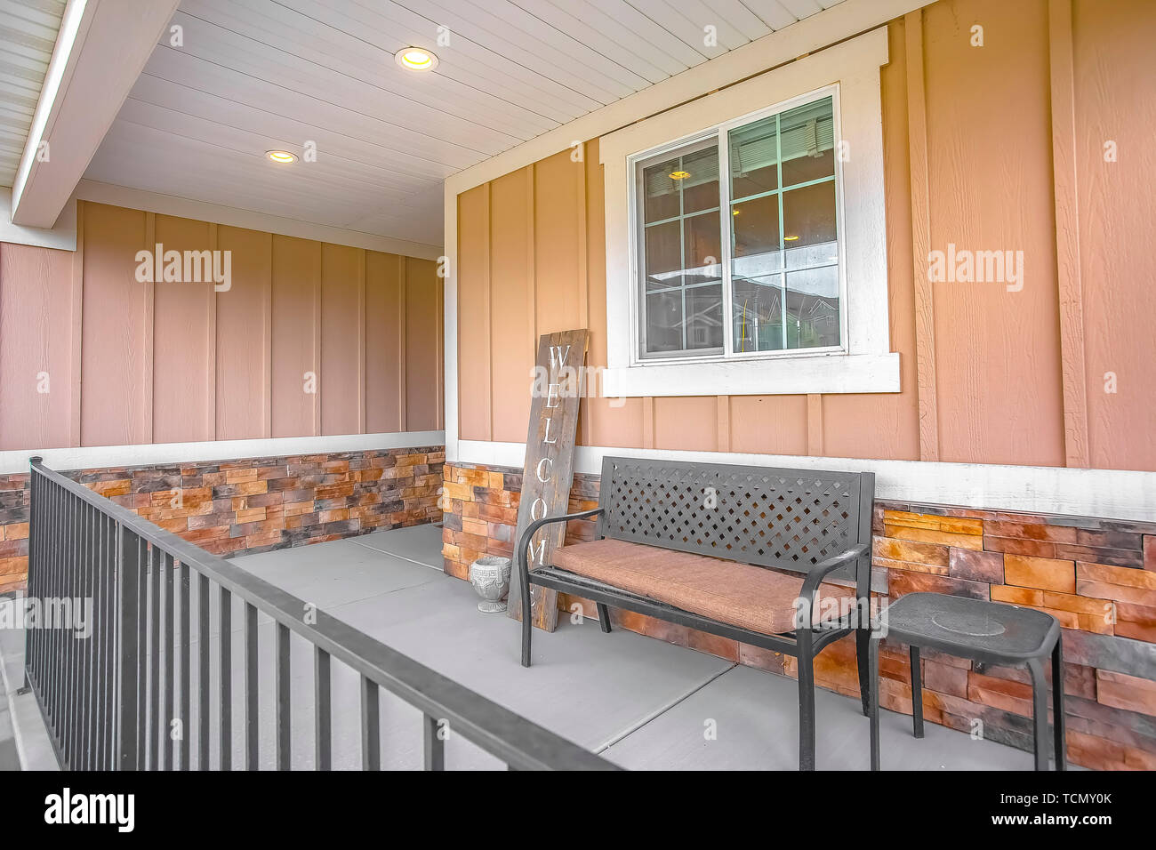 Bench and stool in front of a window at the porch of a home Stock Photo ...