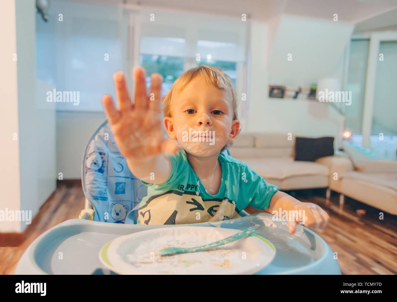 Young baby is eating his food with hands Stock Photo - Alamy