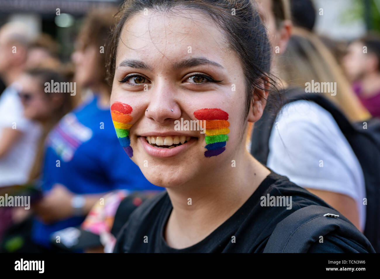 Athens, Greece. 08th June, 2019. Woman smiles with a rainbow flag painted on her face during the ...