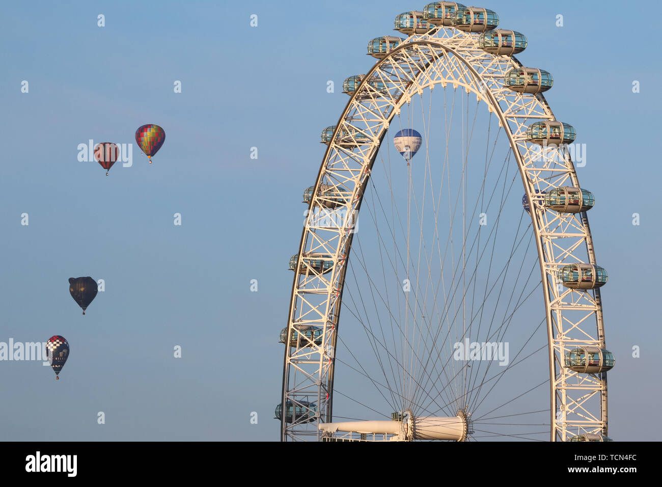 London, UK. 9th June, 2019. Hot air balloons float past the London Eye ...
