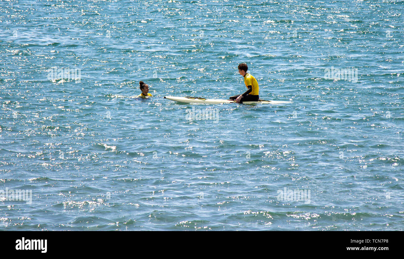 Lifeguard paddling to a swimmer hi-res stock photography and images - Alamy