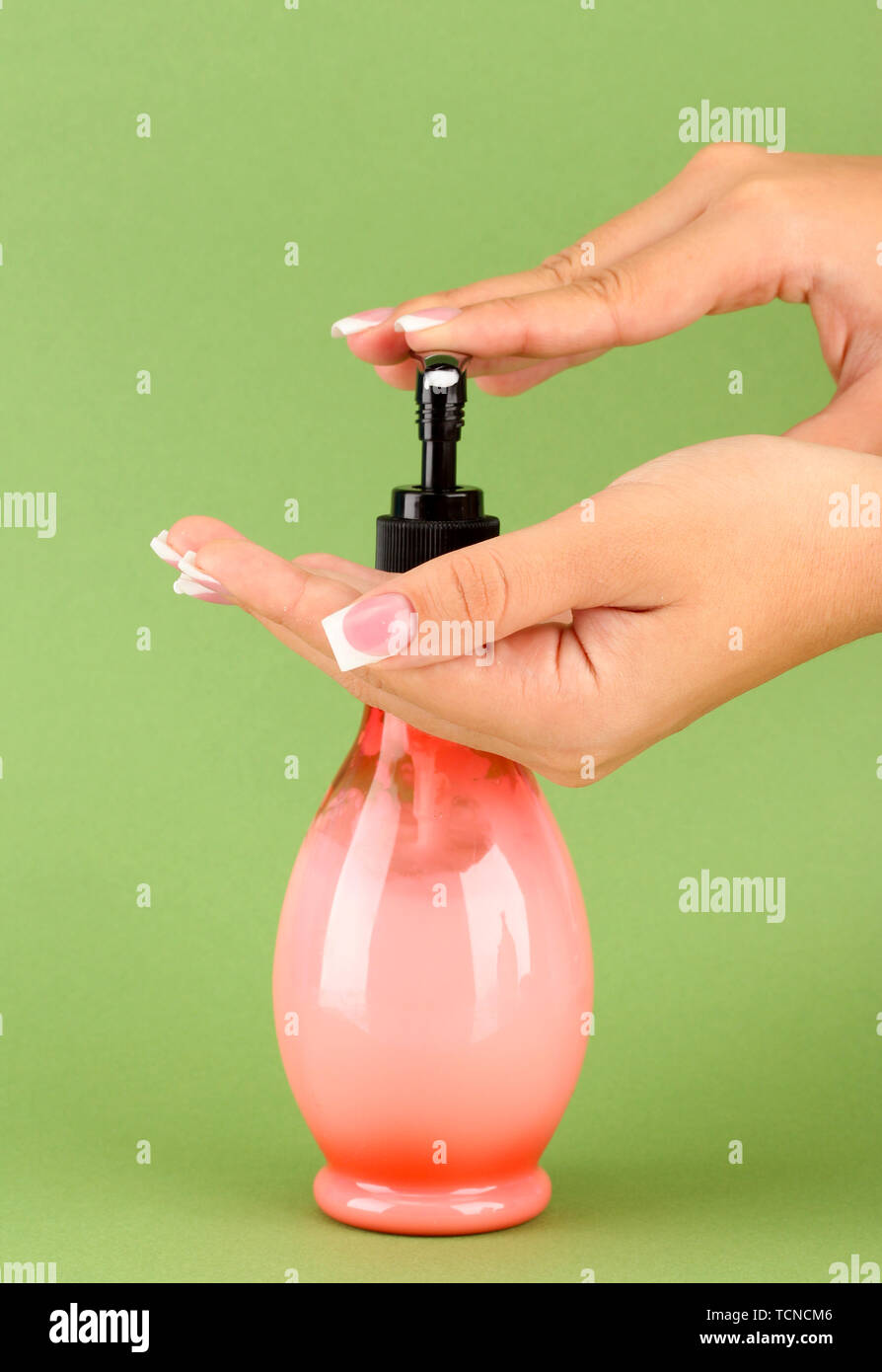 woman squeezing lotion on her hand, on green background close-up Stock ...