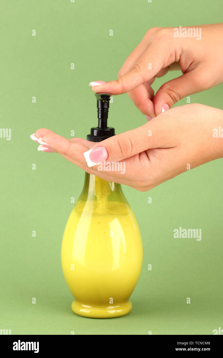 woman squeezing lotion on her hand, on green background close-up Stock ...