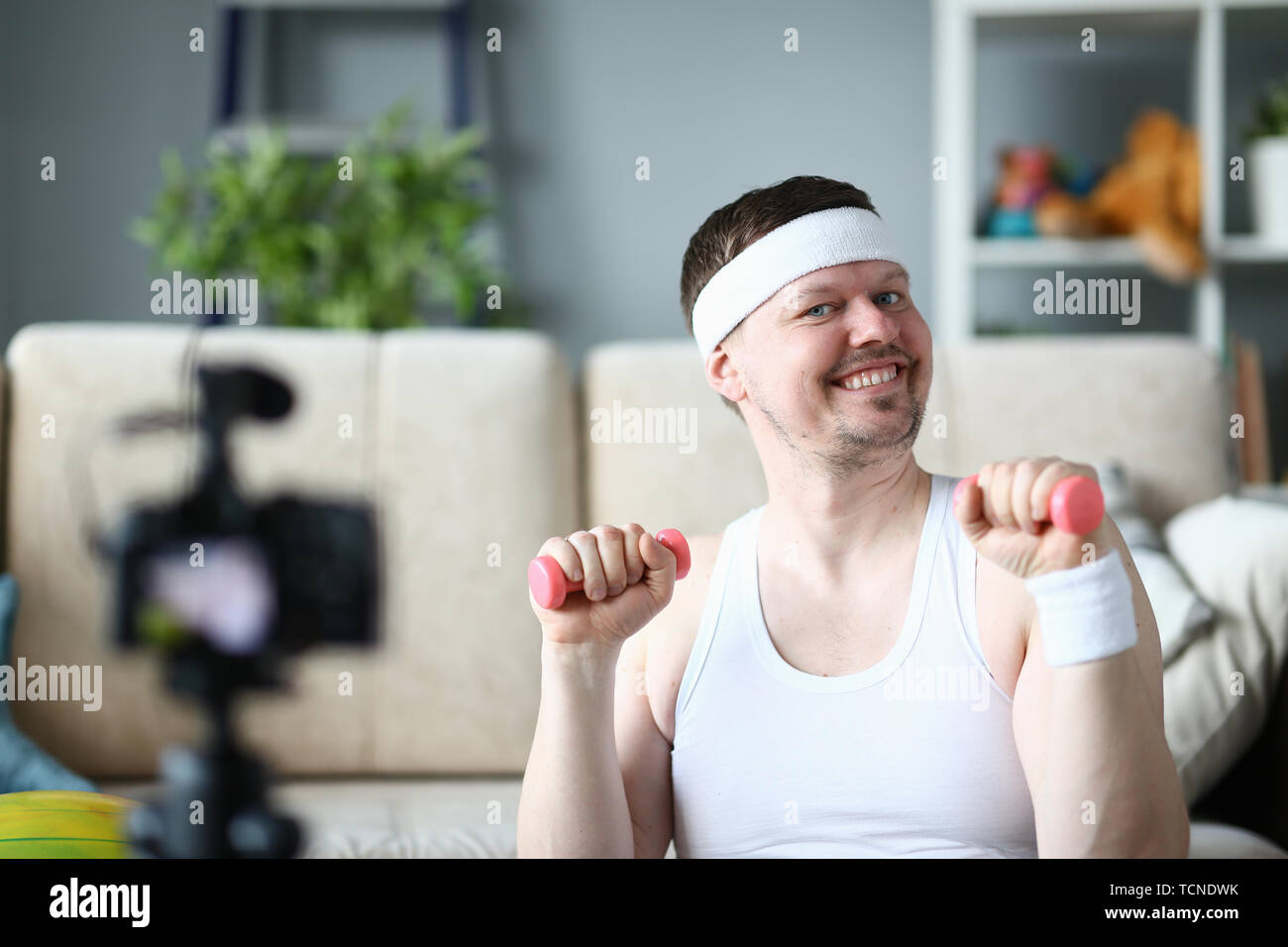 Smiling Man Doing Exercise for Hands with Dumbbell Stock Photo - Alamy