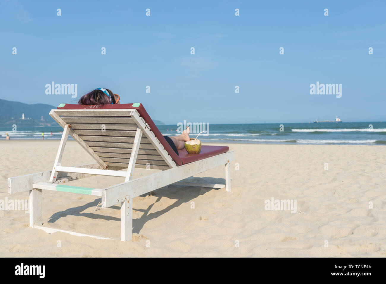 Rear view of woman lying on sandy summer beach chair Stock Photo - Alamy