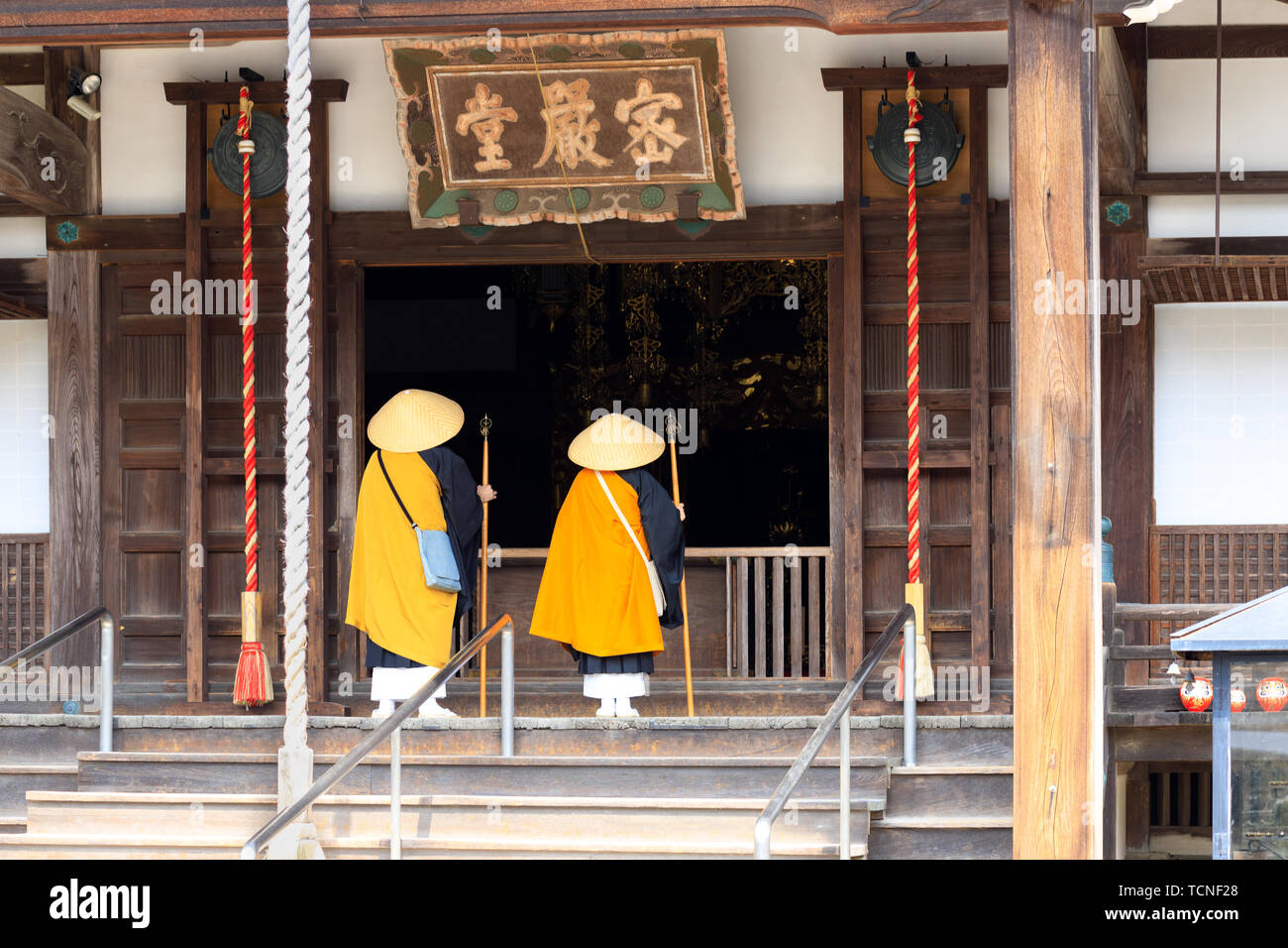 Japanese monks in orange traditional dress praying at temple Stock ...