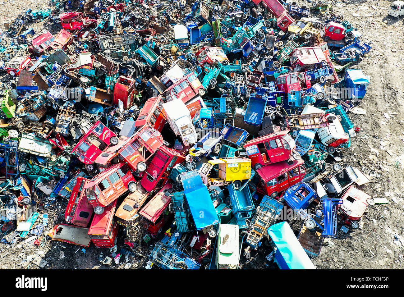 Piled together, scrap-out old motor vehicles waiting to be dismantled ...