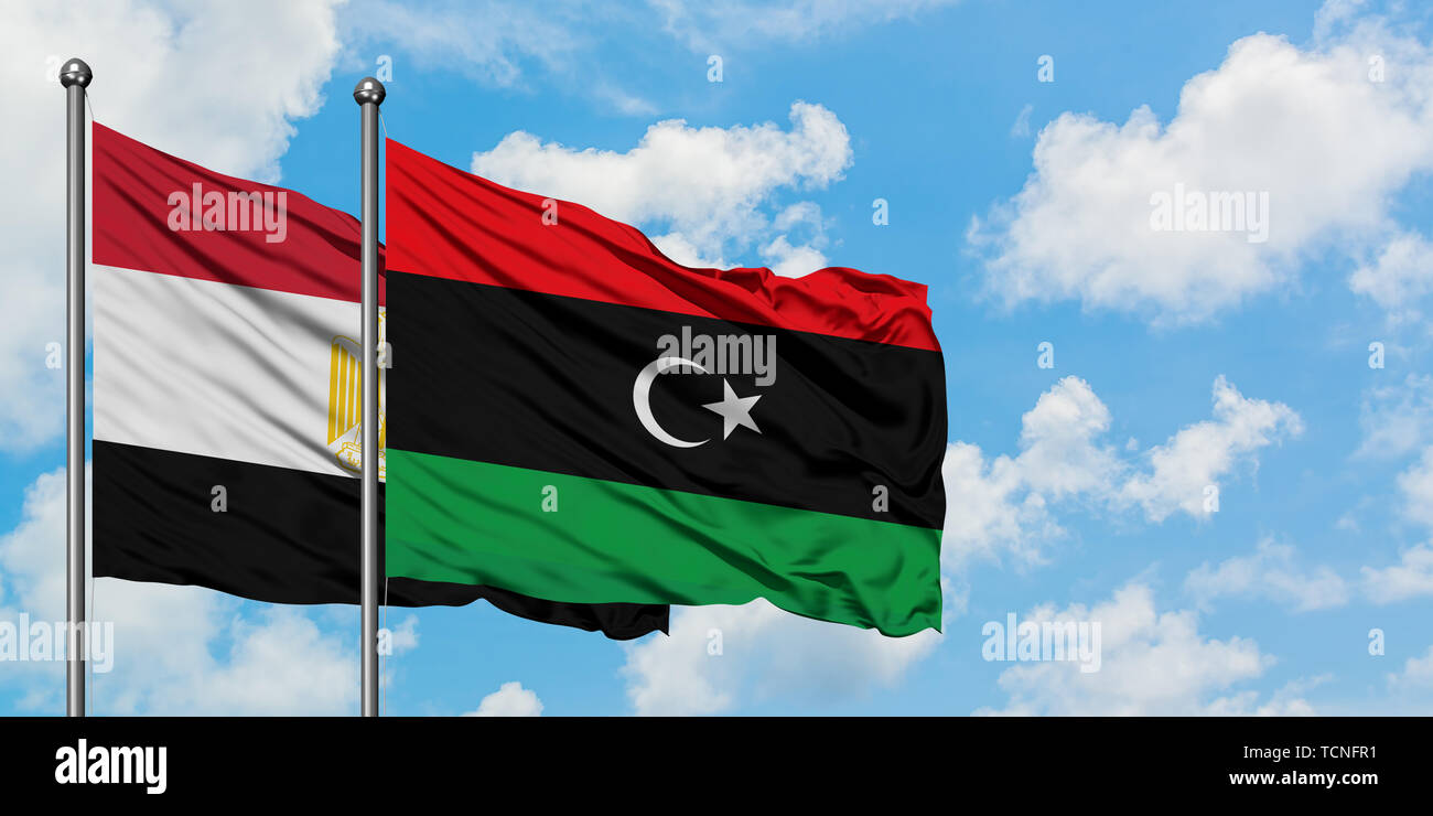 Egypt and Libya flag waving in the wind against white cloudy blue sky ...