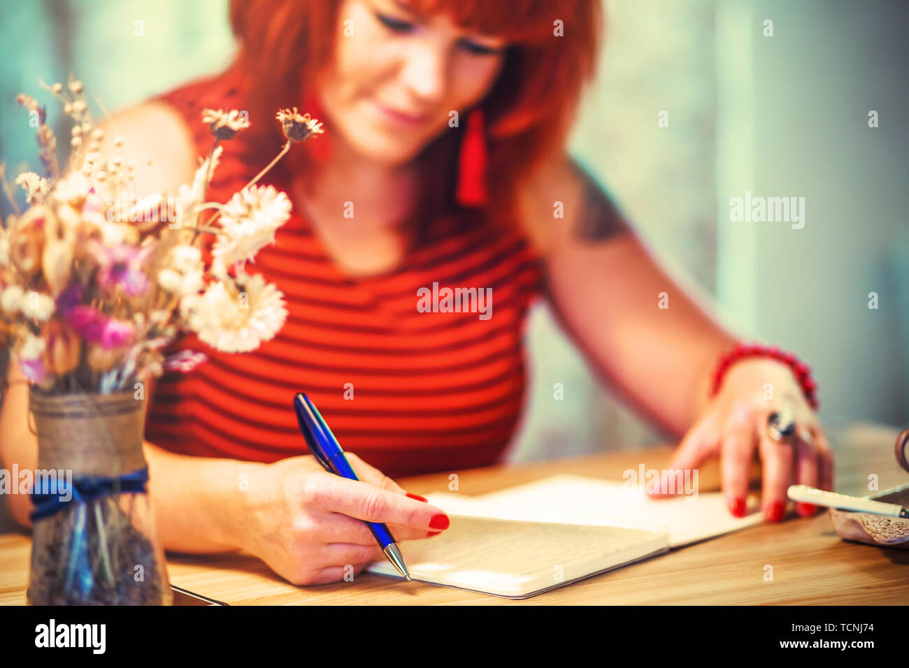 woman is writing in notepad in coofee bar Stock Photo - Alamy