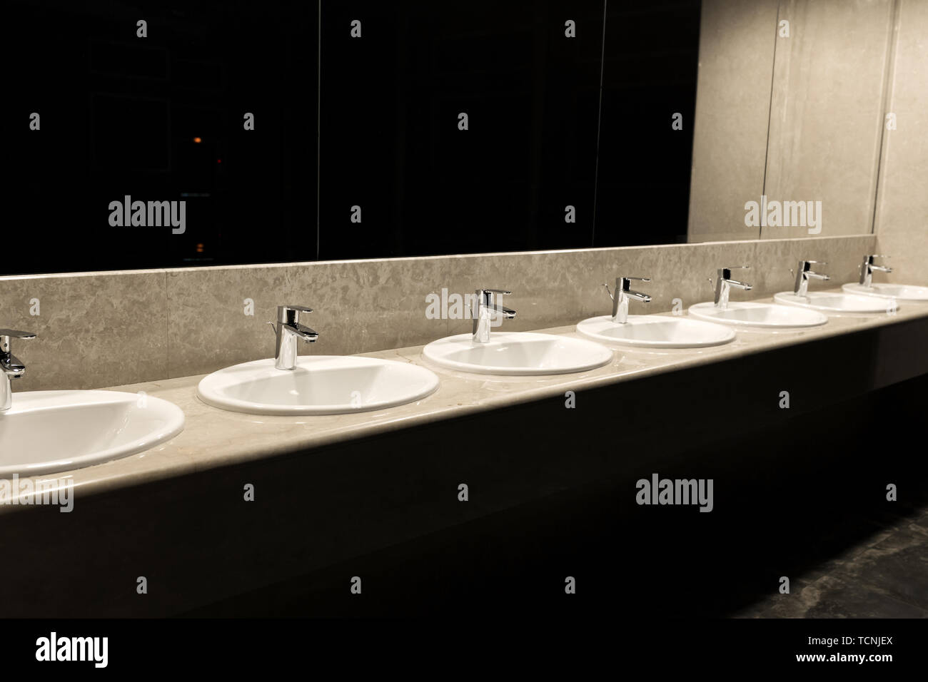 public toilet in the restaurant big mirror and lot of washstands Stock ...