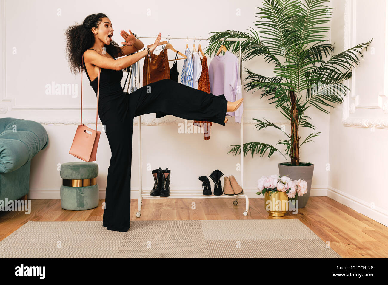 Fashion stylist laughing in studio at clothes rack Stock Photo - Alamy