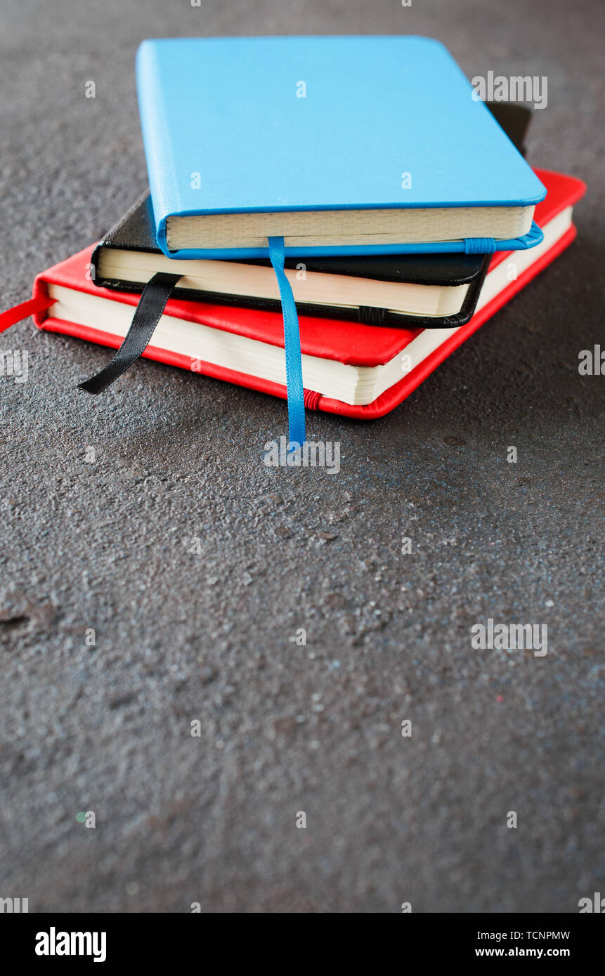 Stack of colorful notebooks for writing or books on dark background ...