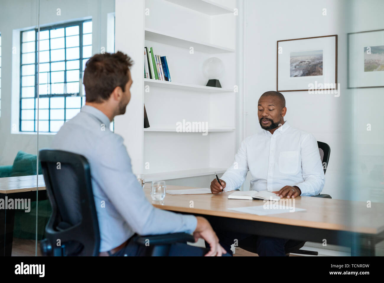 African American office manager going over notes and paperwork with a ...