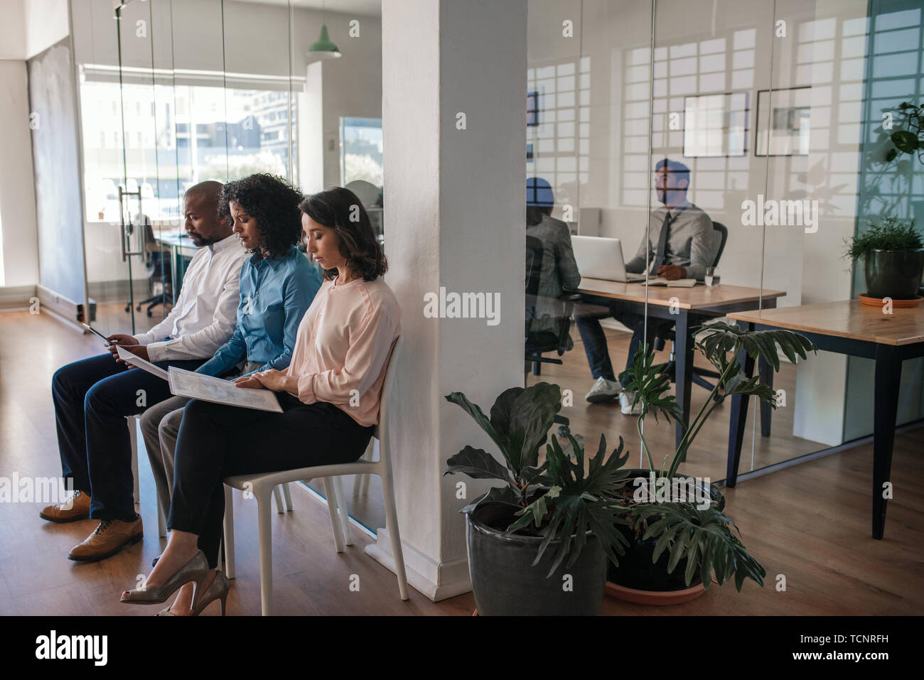 Manager conducting an interview inside of his office with other ...