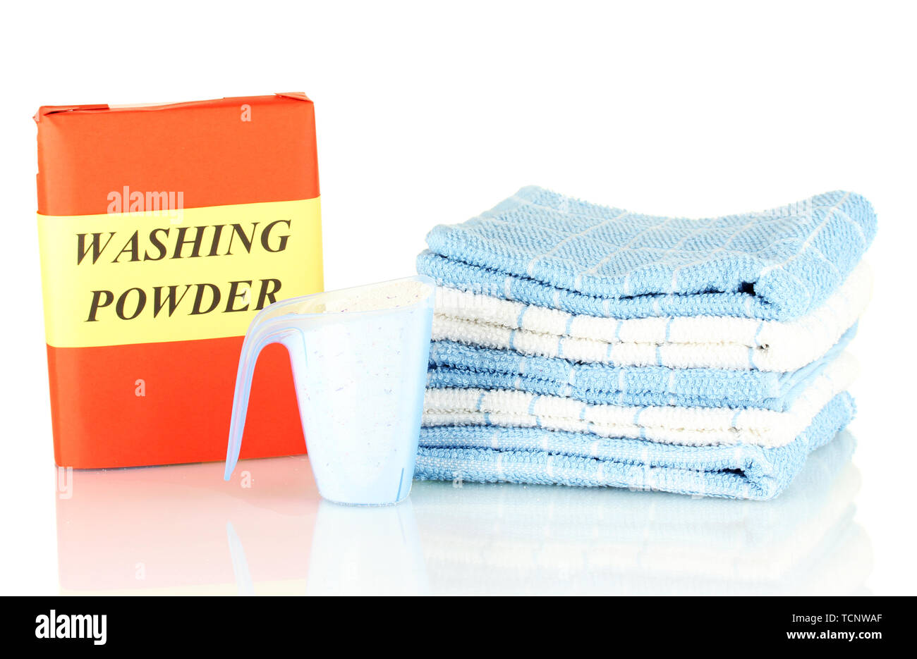 Box of washing powder with blue measuring cup and towels, isolated on ...