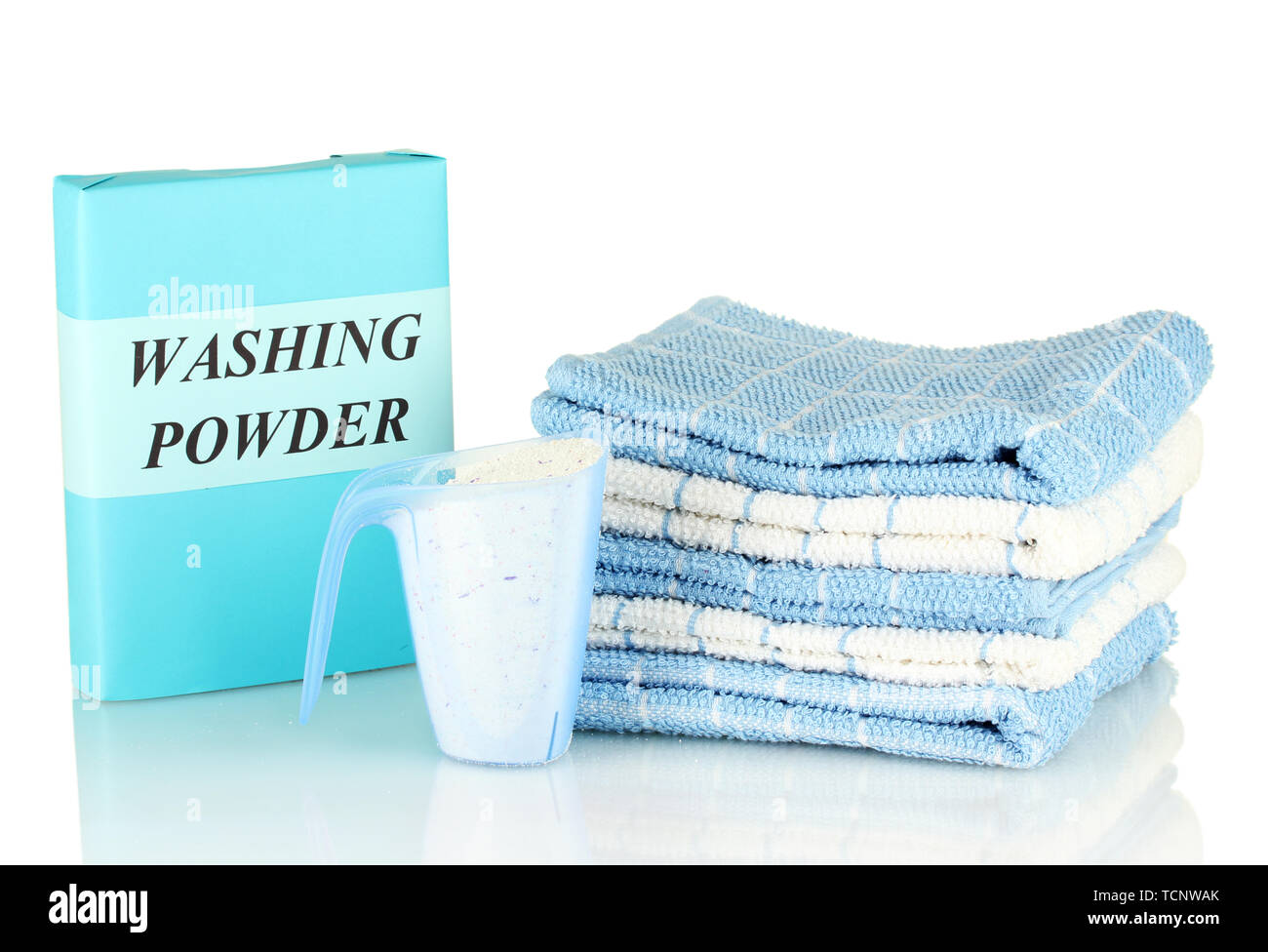 Box of washing powder with blue measuring cup and towels, isolated on ...