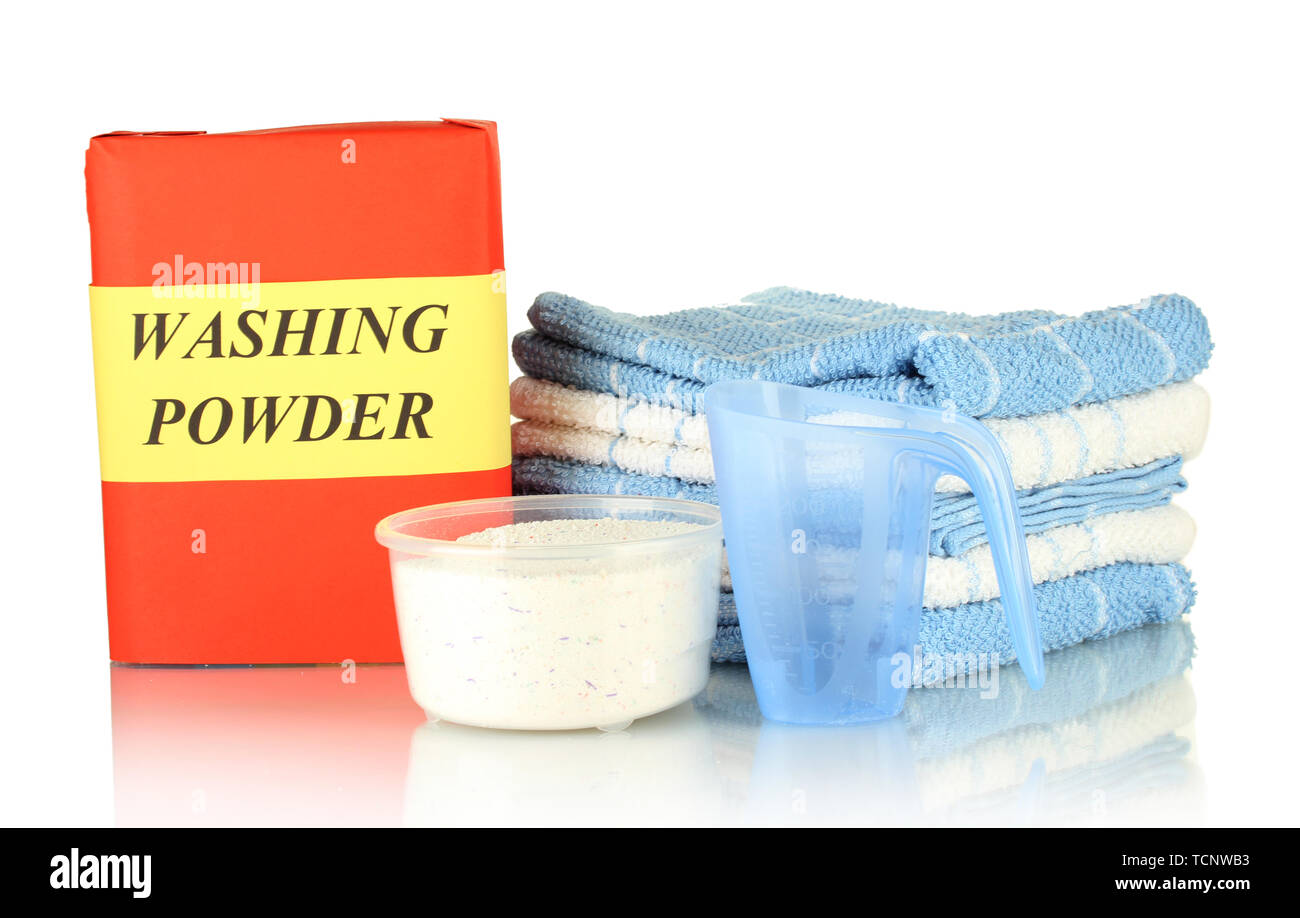 Box of washing powder with blue measuring cup and towels, isolated on ...