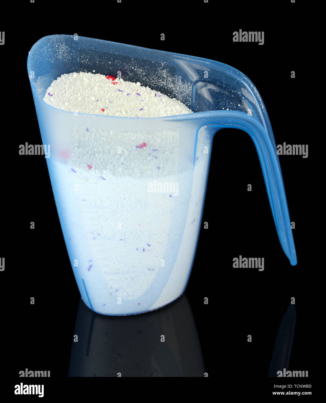 washing powder in a measuring cup, isolated on black Stock Photo - Alamy