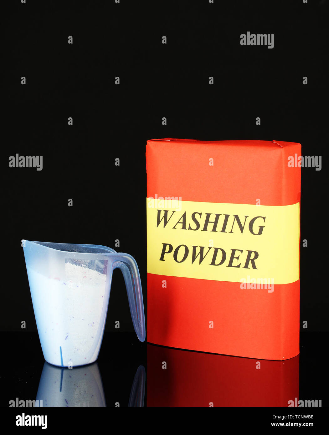 Box of washing powder with blue measuring cup, isolated on black Stock ...