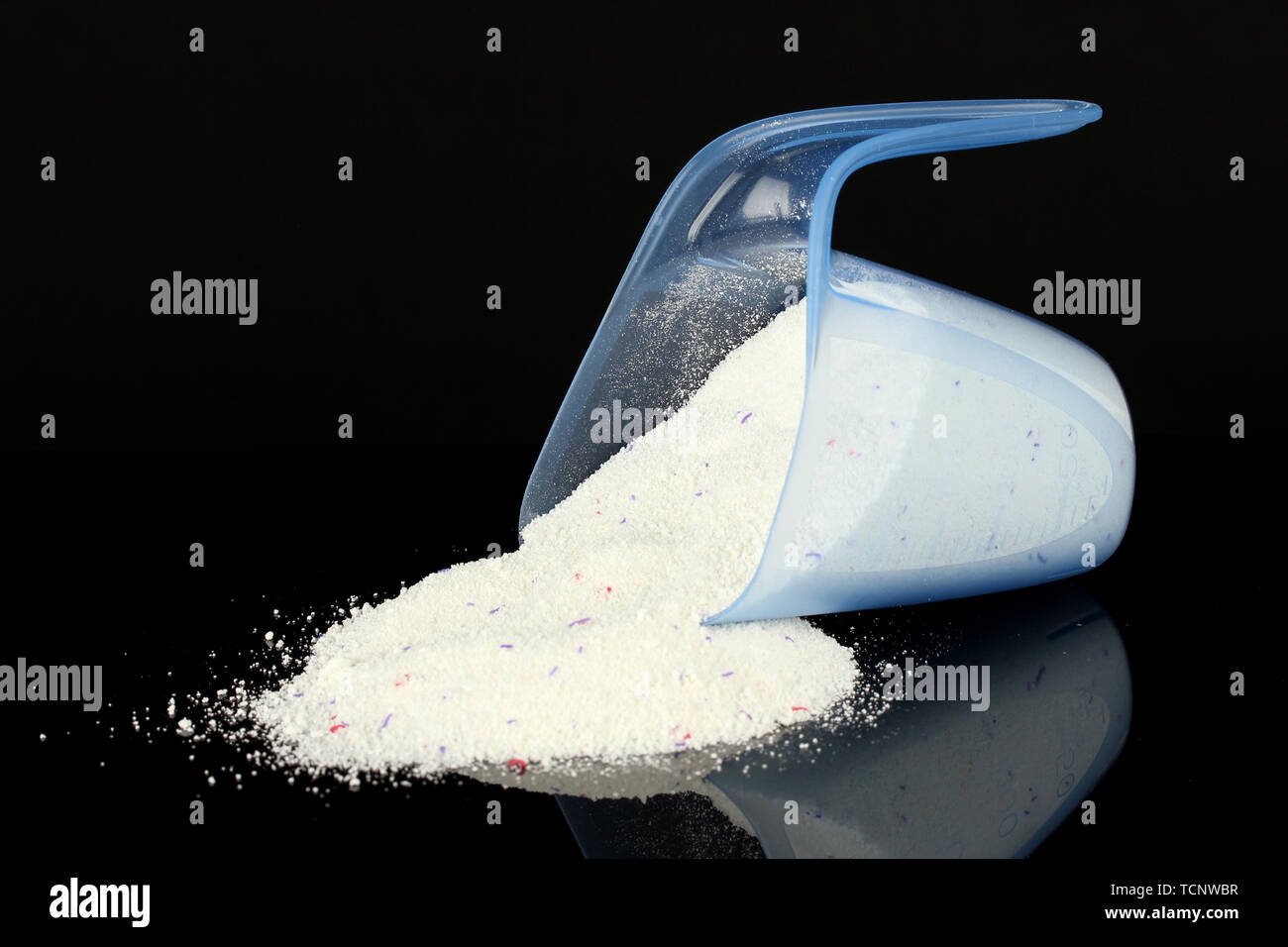 washing powder in a measuring cup, isolated on black Stock Photo - Alamy