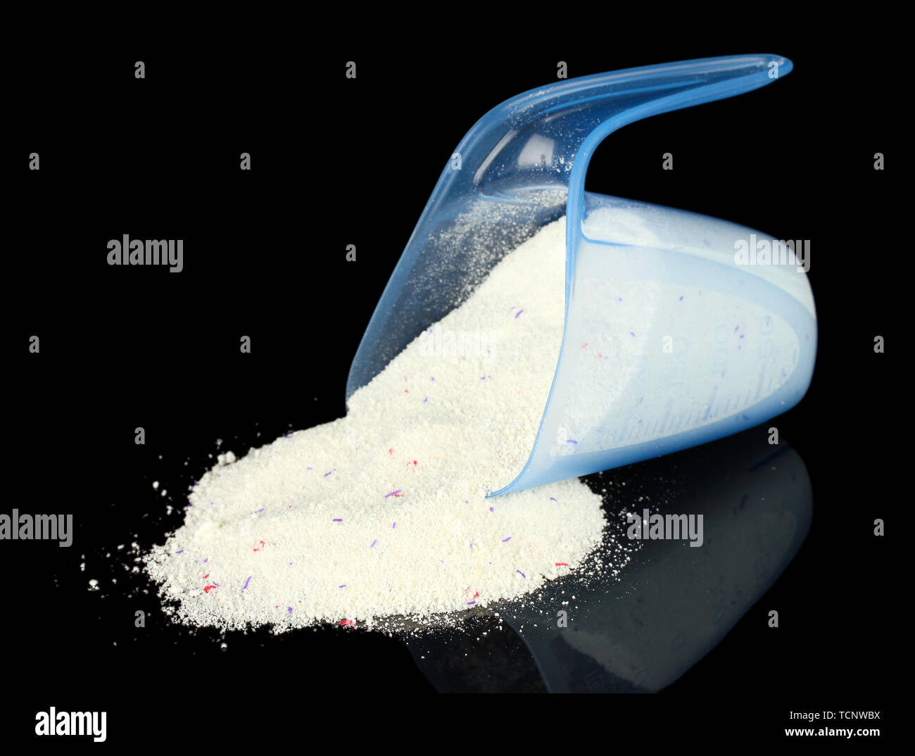 washing powder in a measuring cup, isolated on black Stock Photo - Alamy