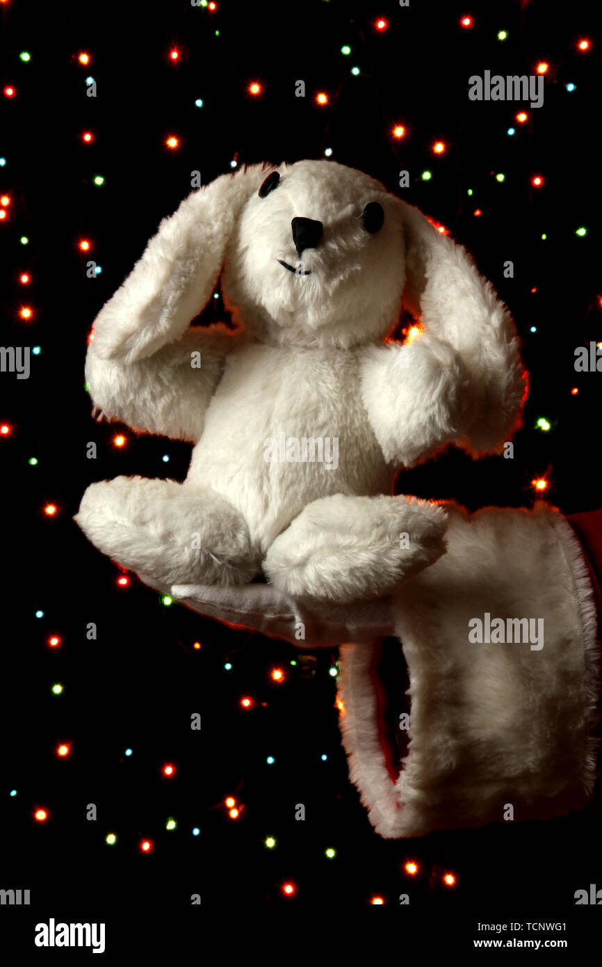 Santa Claus hand holding toy rabbit on bright background Stock Photo ...