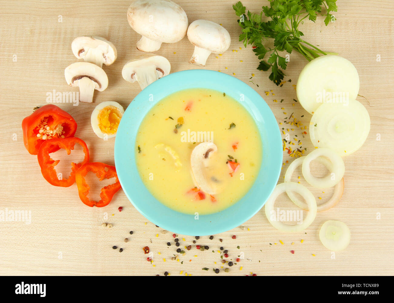 Fragrant soup in blue bowl with ingredients around on table close-up ...