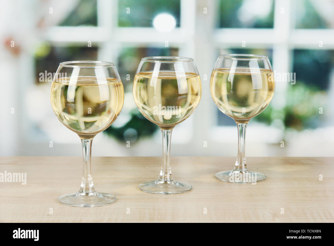 White wine in glass on window background Stock Photo - Alamy