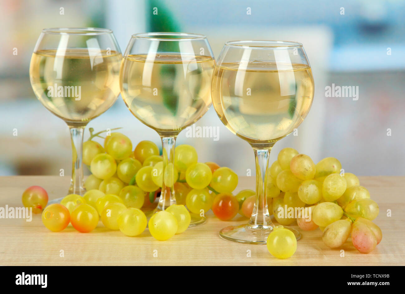 White wine in glass on room background Stock Photo - Alamy