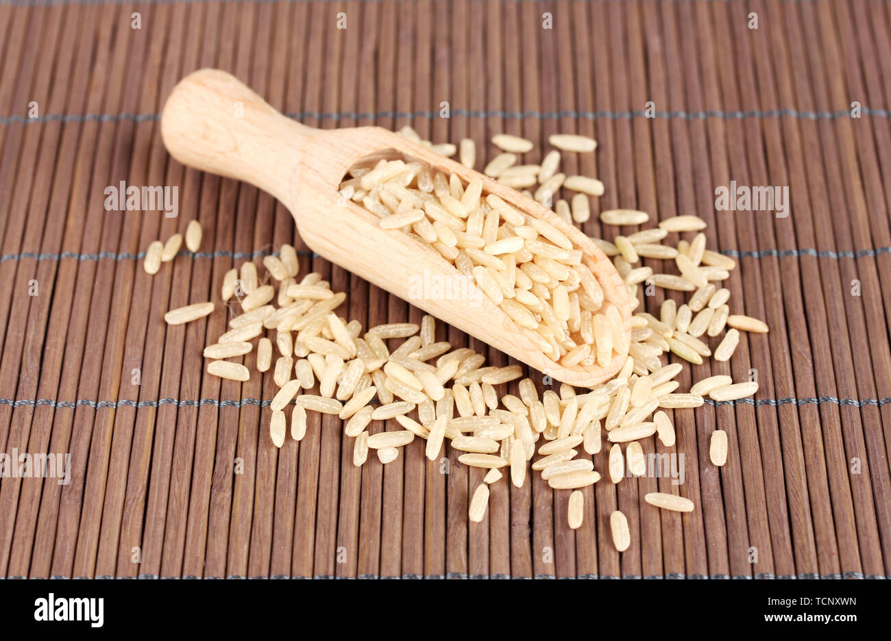 rice in wooden scoop on bamboo mat Stock Photo - Alamy