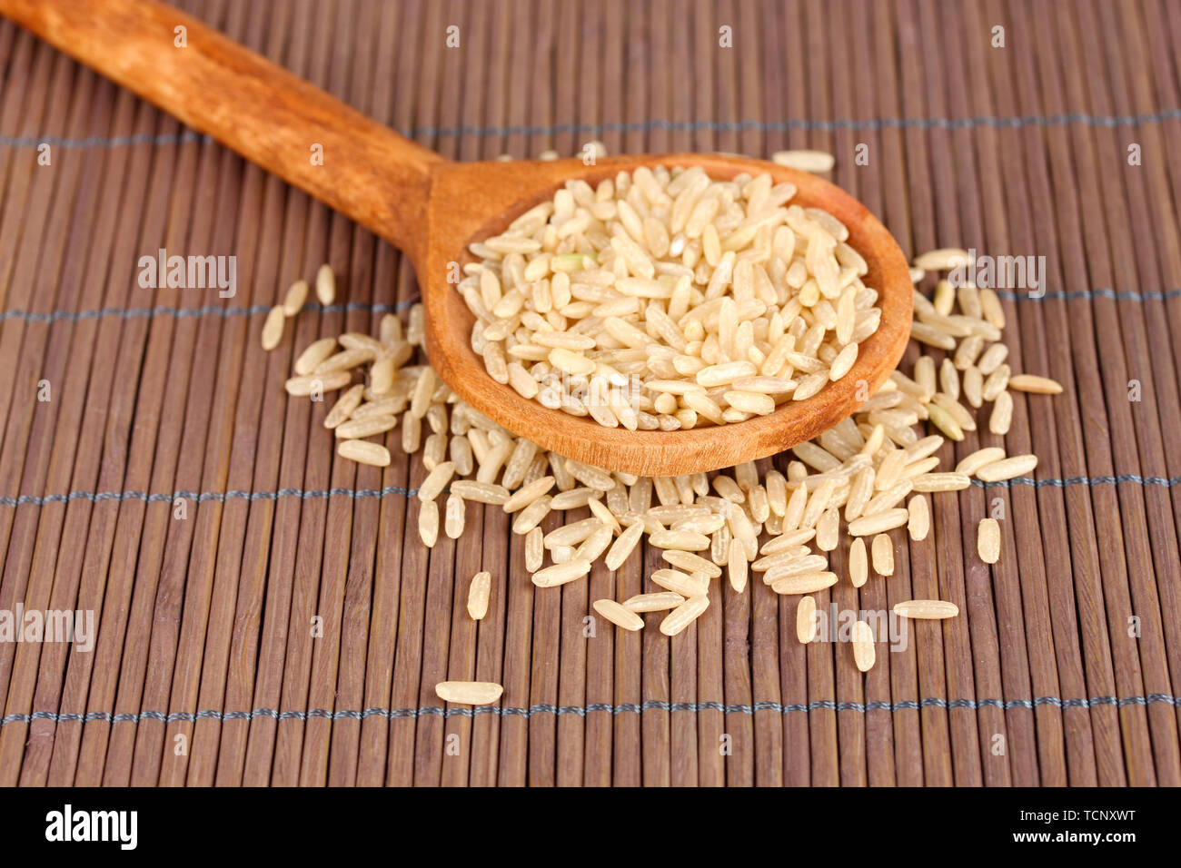 rice in wooden spoon on bamboo mat Stock Photo - Alamy