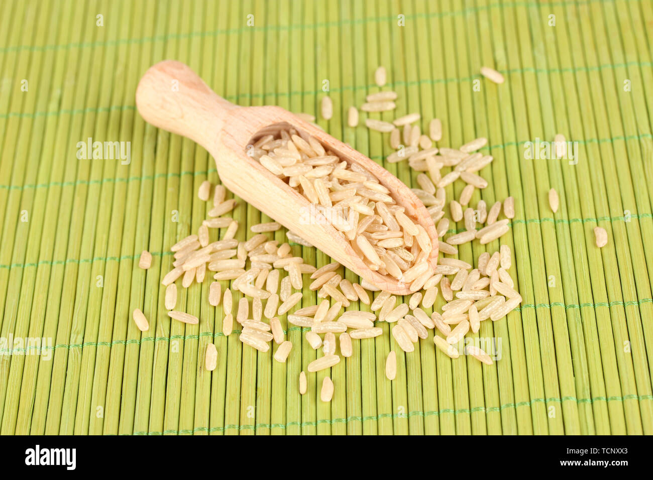 rice in wooden scoop on bamboo mat Stock Photo - Alamy