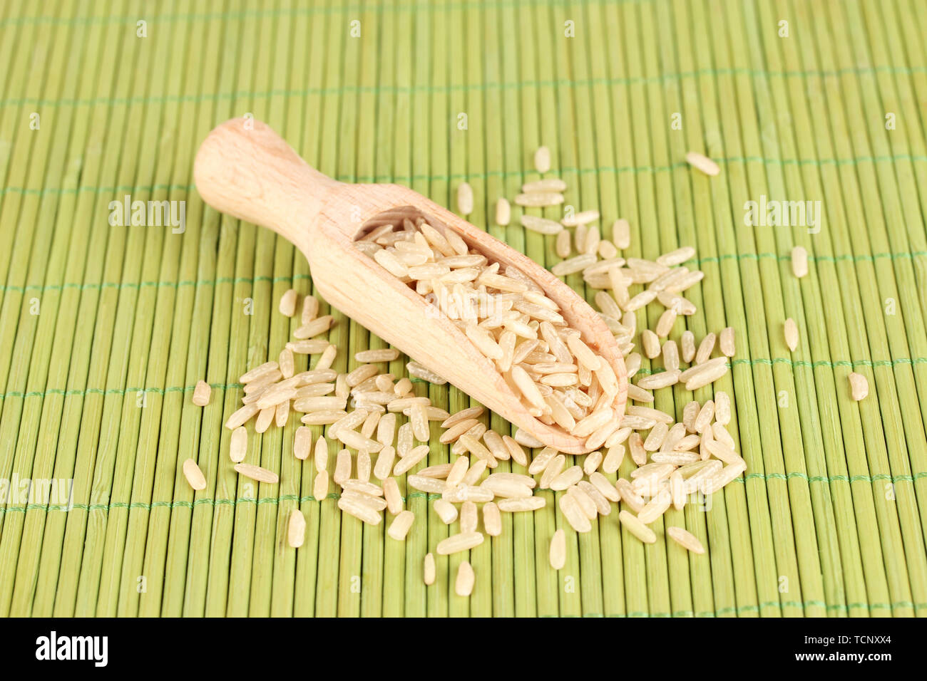 rice in wooden scoop on bamboo mat Stock Photo - Alamy