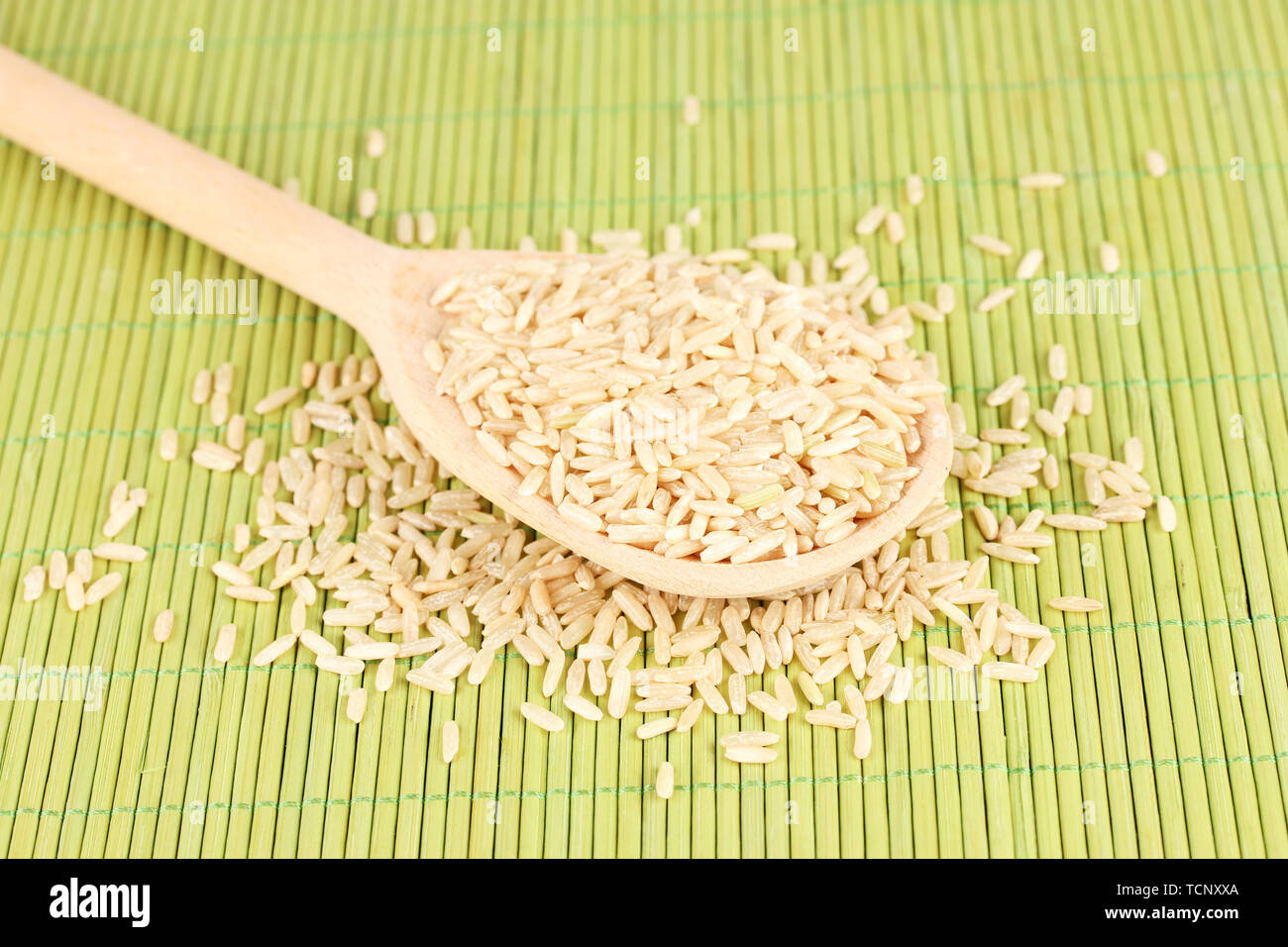 rice in wooden spoon on bamboo mat Stock Photo - Alamy