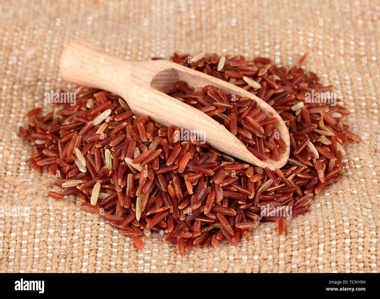 red rice on sacking in wooden scoop Stock Photo - Alamy