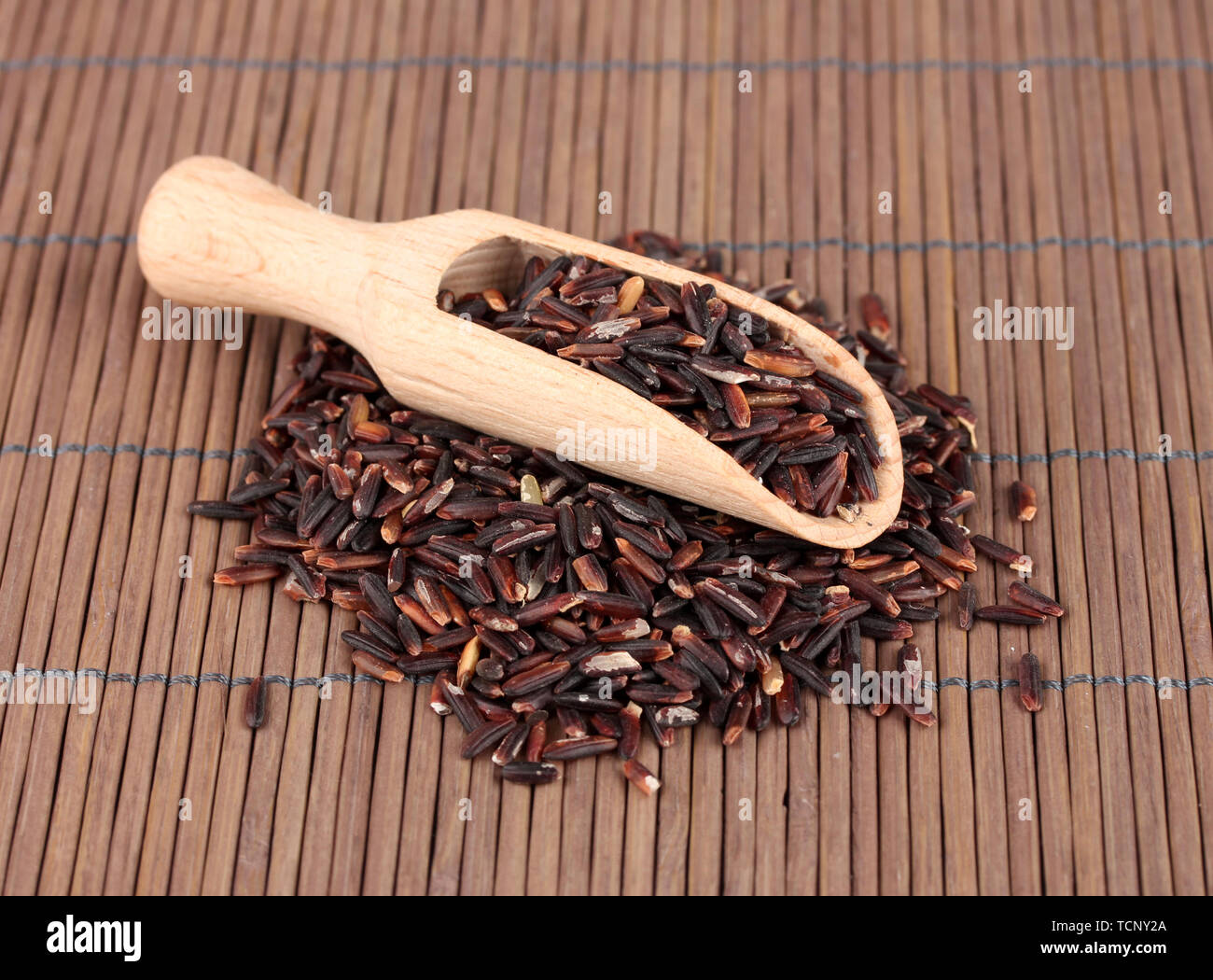 black rice in wooden scoop on bamboo mat Stock Photo - Alamy