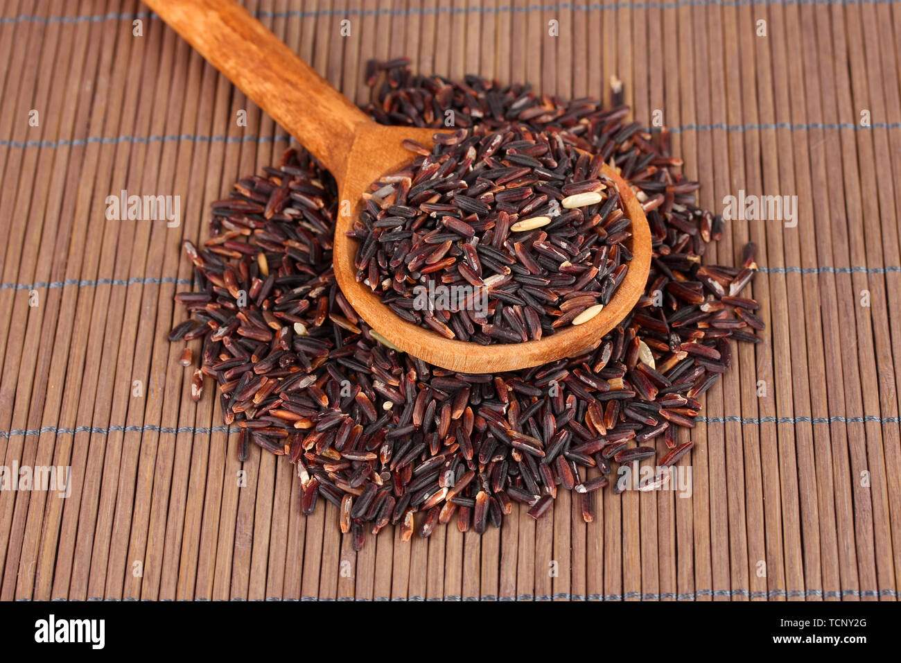 black rice in wooden spoon on bamboo mat Stock Photo - Alamy