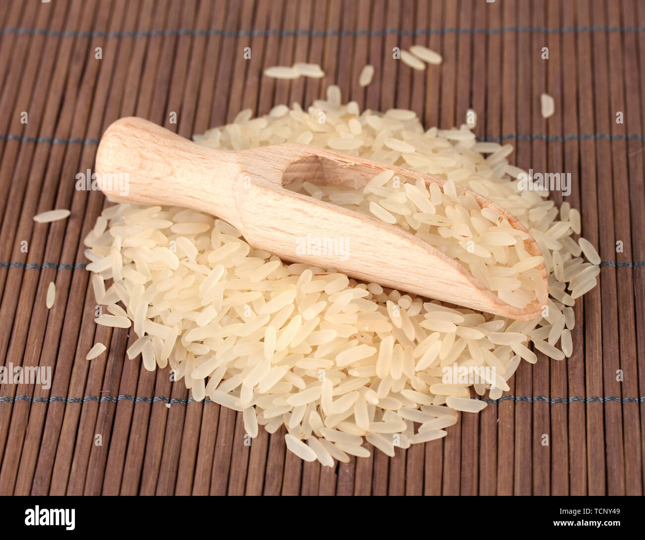 rice in wooden scoop on bamboo mat Stock Photo - Alamy